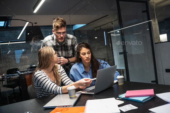 Programmers work alongside their colleagues in an office Stock Photo by milanzeremski